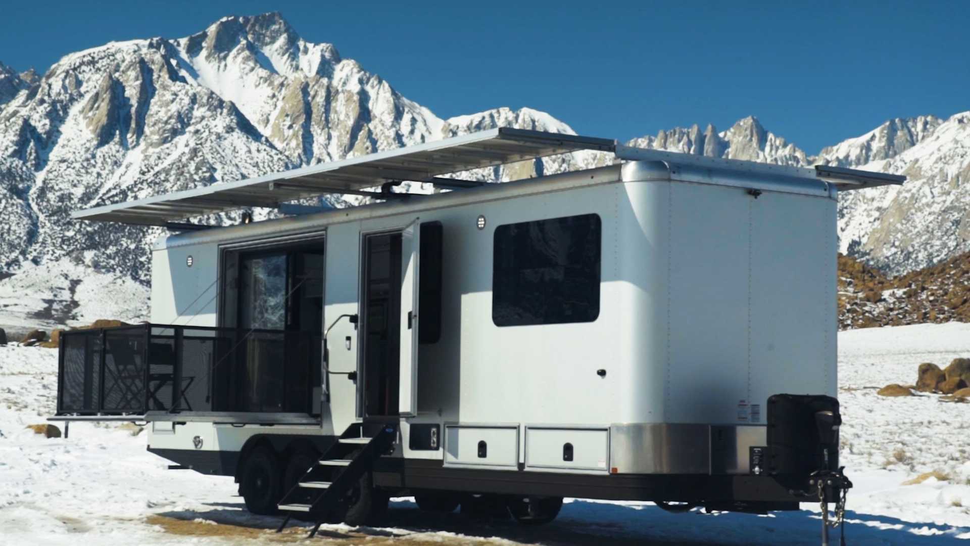 The Living Vehicle Is An Off-Grid Camper With A Folding Patio Deck